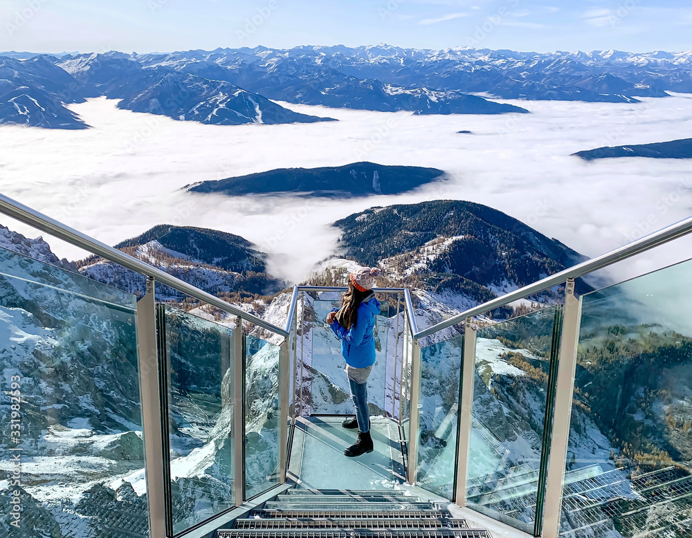Female person standing on sky walk glass at Dachstein, enjoying view of ...