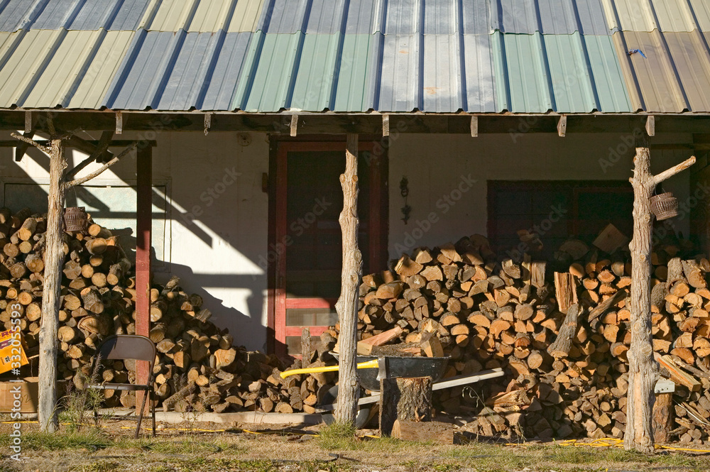 Stack of logs in front of cabin in Mescalero Apache Indian Reservation ...