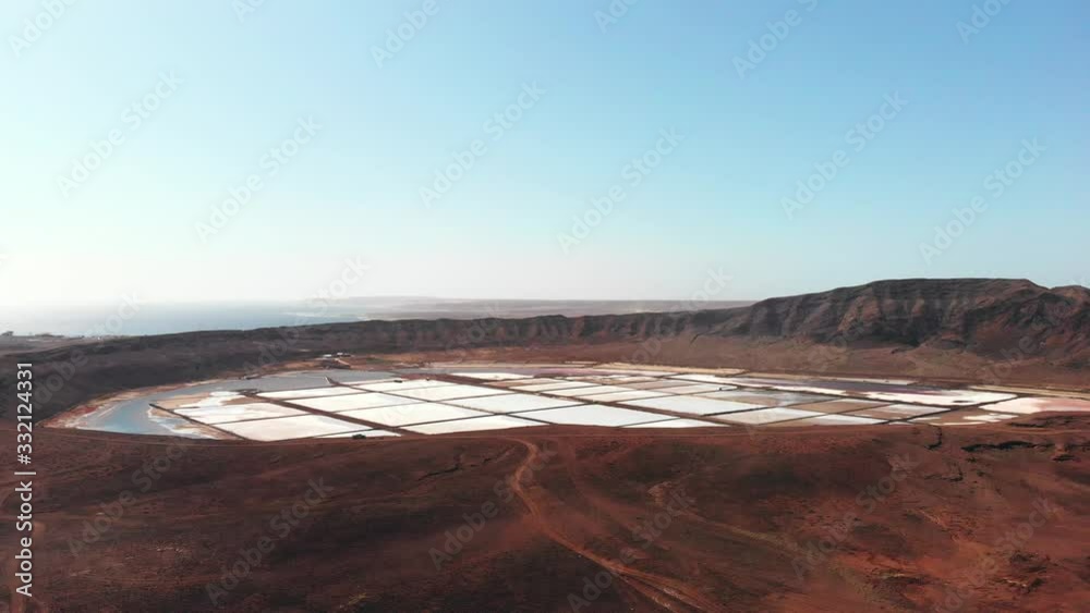 Pulling away from huge, dormant red volcano with salt ponds in its ...