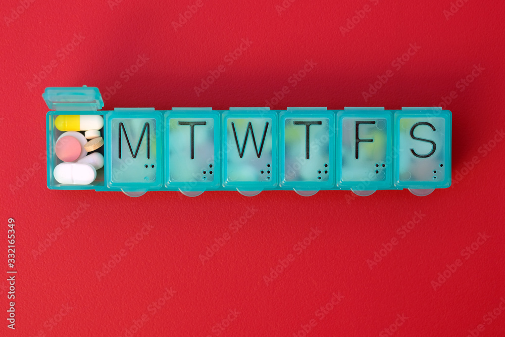 Green plastic pill box for seven days. Pill container top view ...