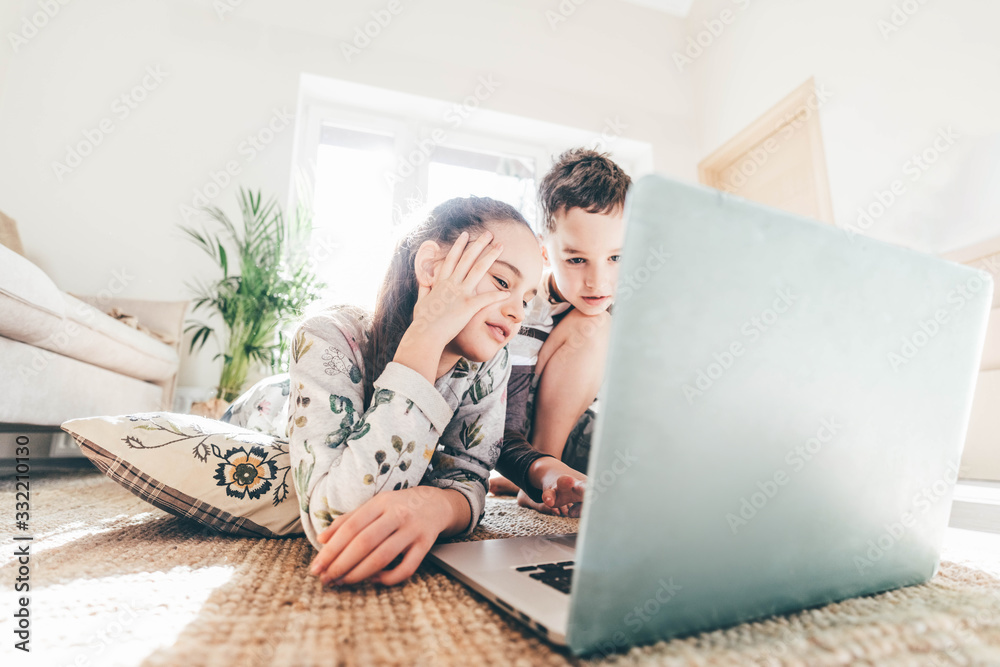 Cute children sister and brother watching on laptop, siblings boy girl ...