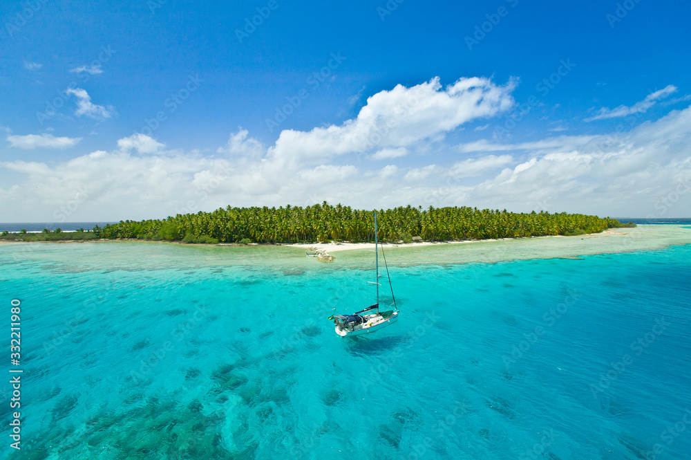 Foto de Sailing yacht anchoring in the shallow waters of suwarrow atoll ...