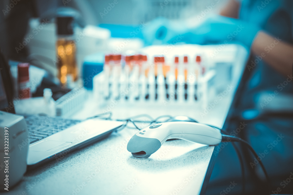 Bar codes scanner, blood sample tubes and laptop with lab technician ...