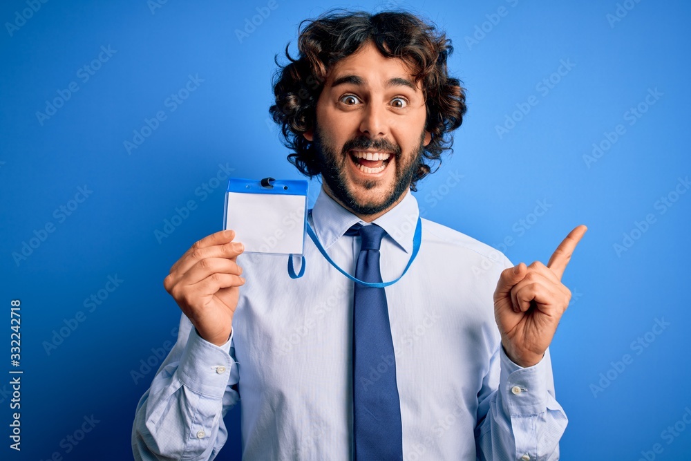 Young handsome business man with beard holding id card identification ...