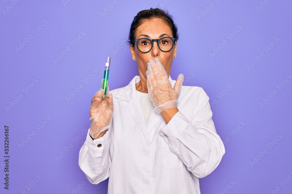 Middle age senior scientist woman wearing laboratory coat holding ...