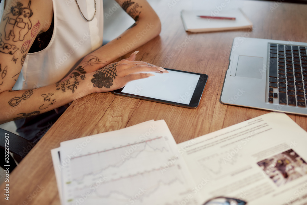 New software. Young tattooed woman with short haircut using digital ...