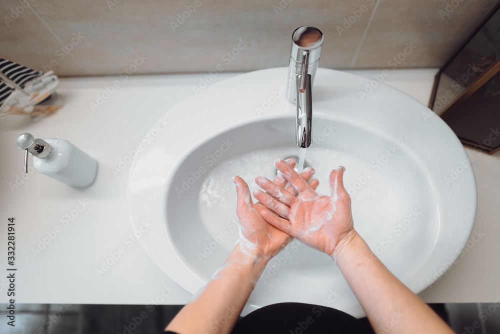 beautiful woman carefully washing hands with soap and sanitiser in home ...