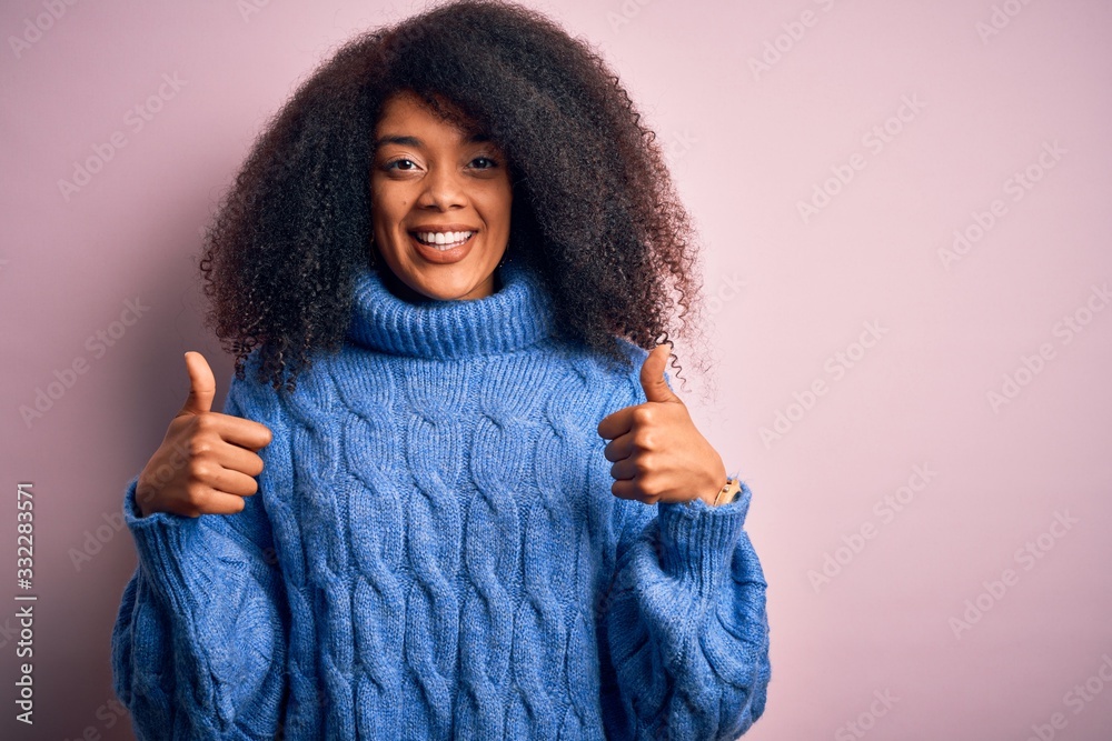 Young beautiful african american woman with afro hair wearing winter ...