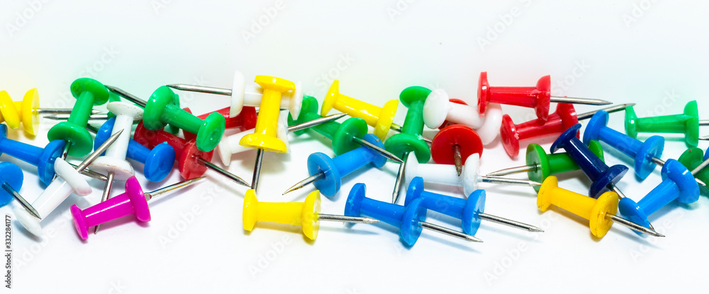 Sharp pin for attaching paper. Colored stationery buttons laid out on ...