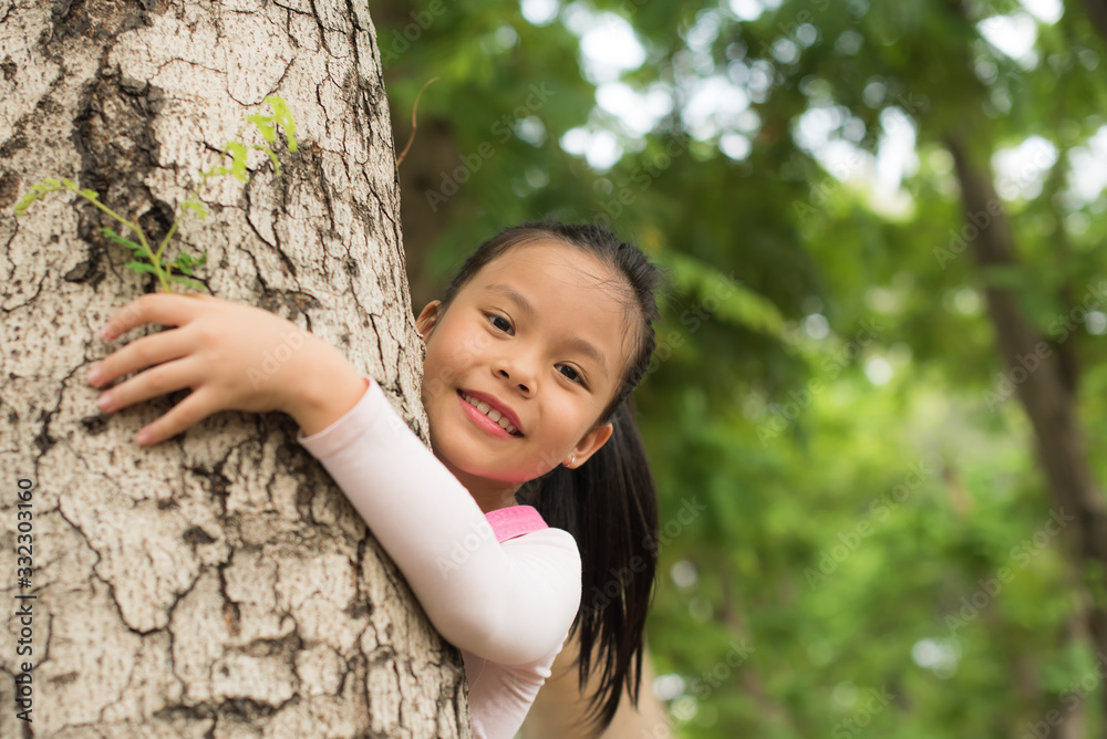 tree hugging, little asian girl giving a tree a hug against spring ...