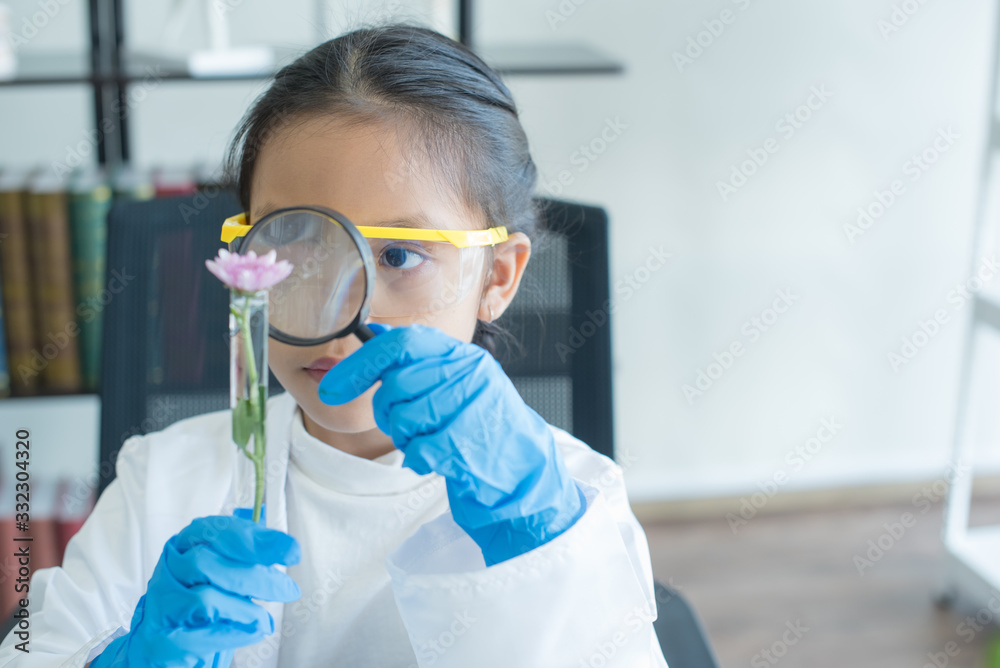 little asian girl elementary school looking into magnifying glass at ...