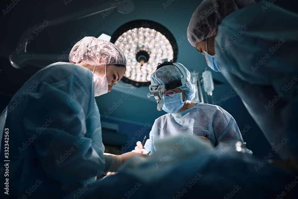 Medical team in the operating room, dark background. The theater of the ...
