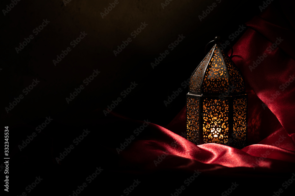 Dark photography of lantern with a dim lighting effect on a red satin ...