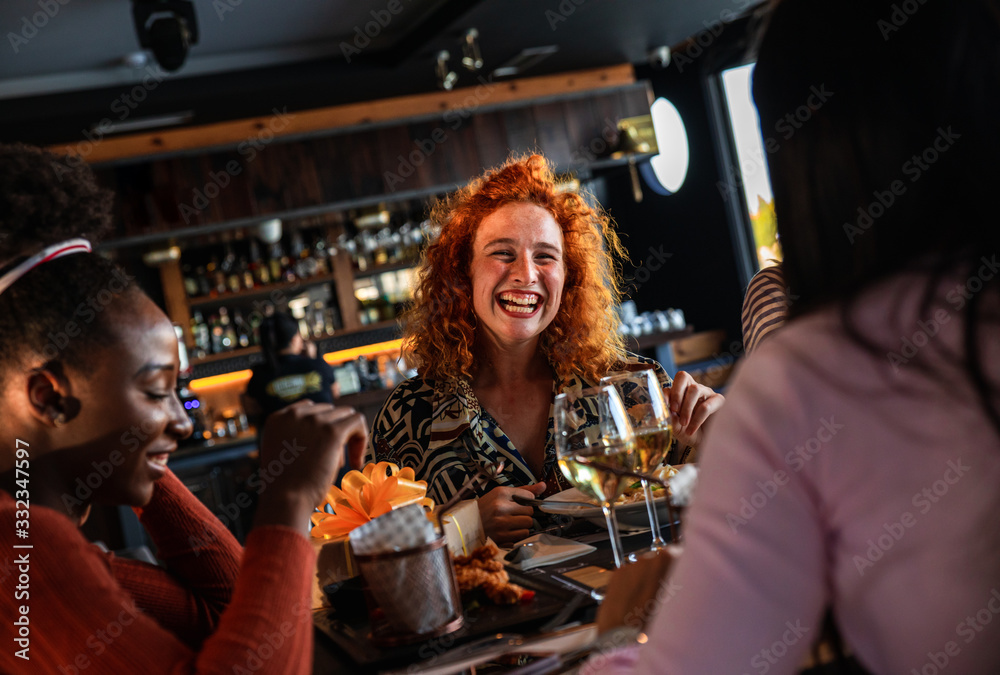 Group of young female friends having fun in restaurant, talking and ...