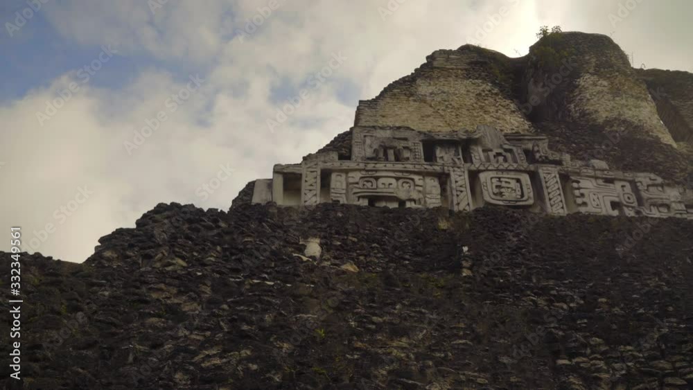 Slide right looking upward at Xunantunich Mayan carvings on the pyramid ...