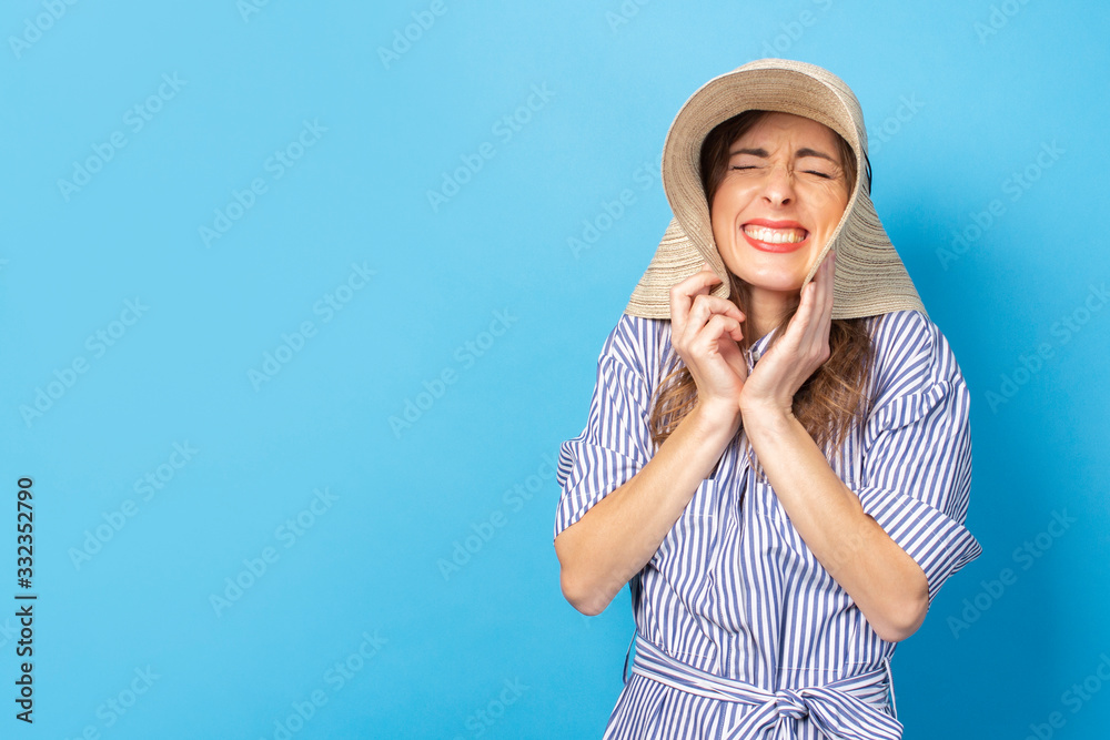 squint young girl in hat and dress on a blue background. Concept of ...