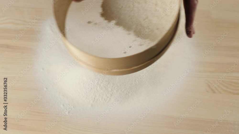 Video „Professional baker hands sift flour through a wooden sieve on ...