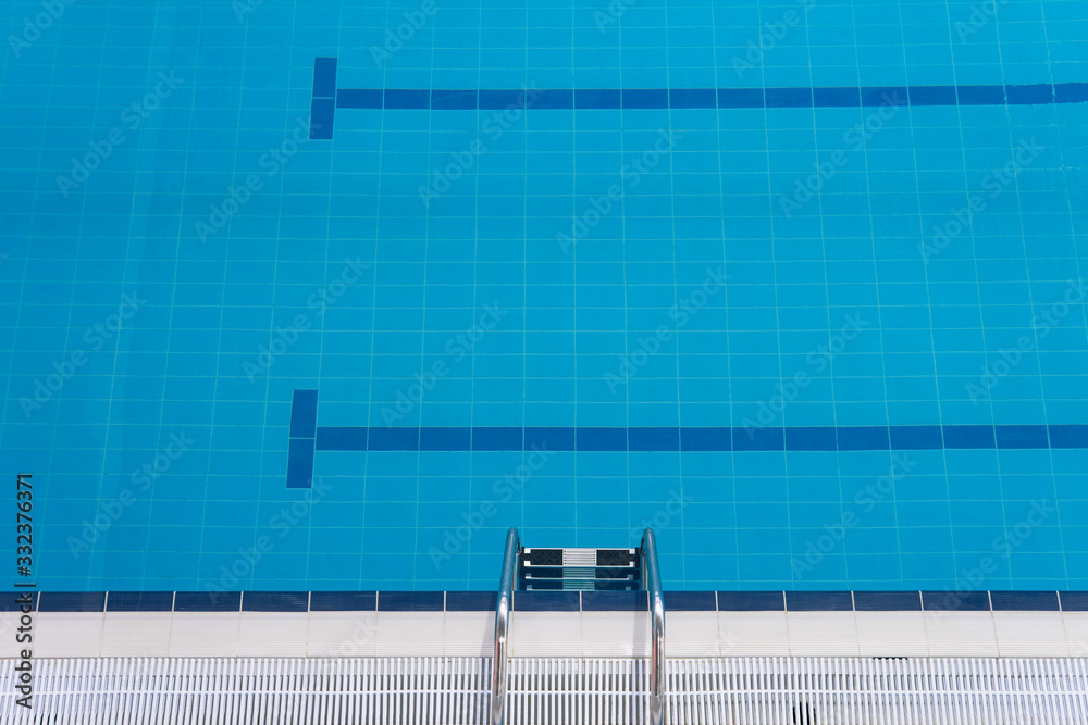 Swimming pool edge with a steel ladder Top view Empty sports swimming ...