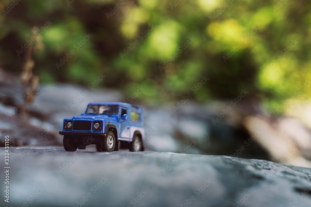 Blue Suv which is an old fashioned style on the rocks and posing front ...