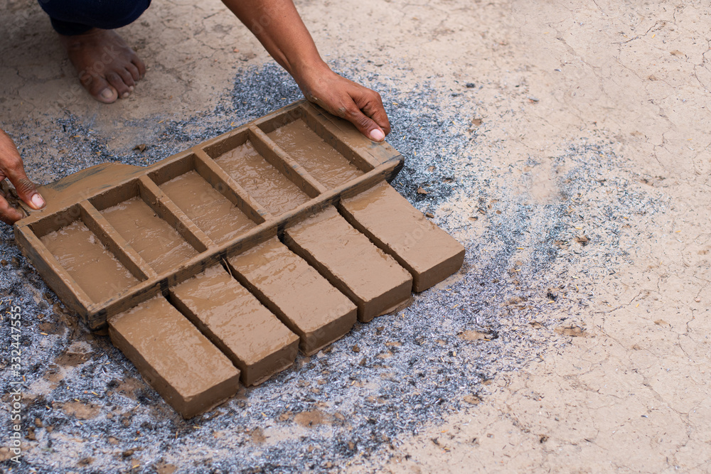 Hands of male worker were pull up the mold from formed mud (5 pieces ...
