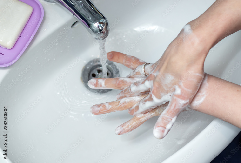 Woman washing hands with soap under the faucet in bathroom. Step by ...