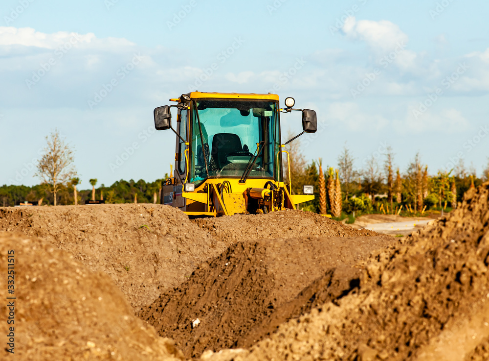 The cap of a front end loader is viewed across several piles of fresh ...