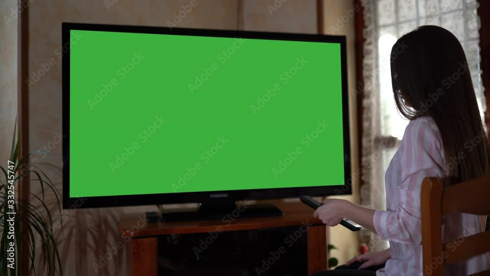 Television green screen, pretty girl watching modern TV at home and ...