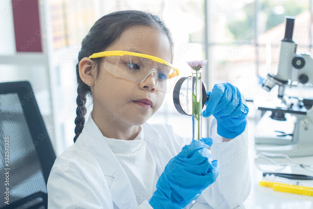 little asian girl elementary school looking into magnifying glass at ...