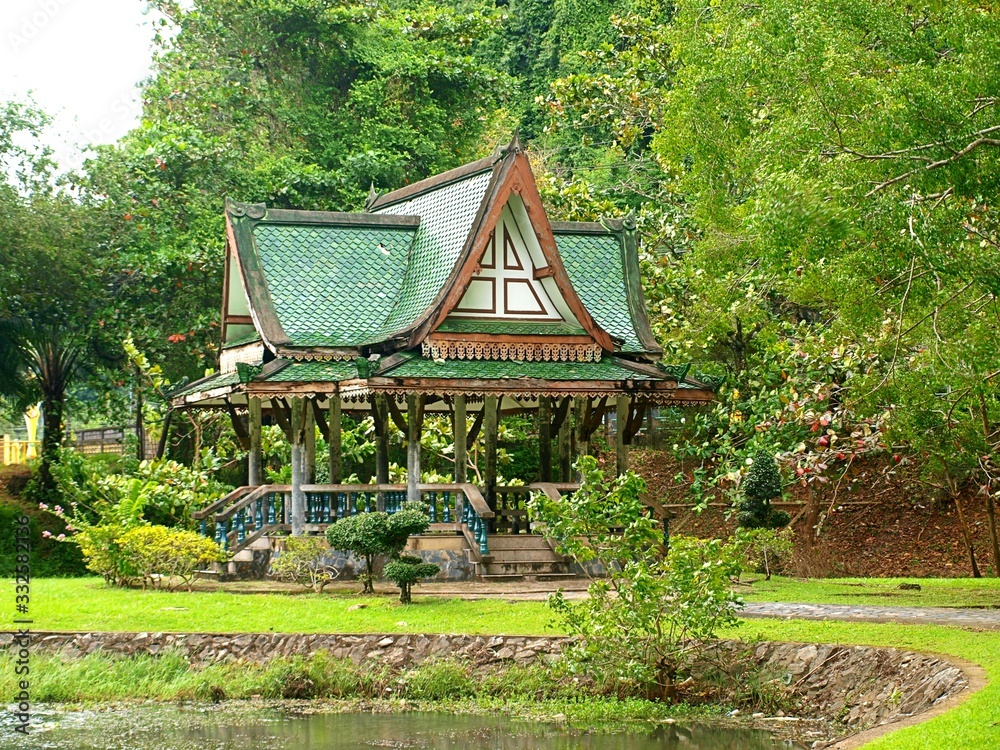 Gazebo with green roof in the park. Garden pavilion in traditional ...