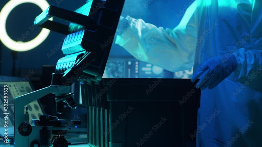Scientist in protection suits and masks working in research lab using ...