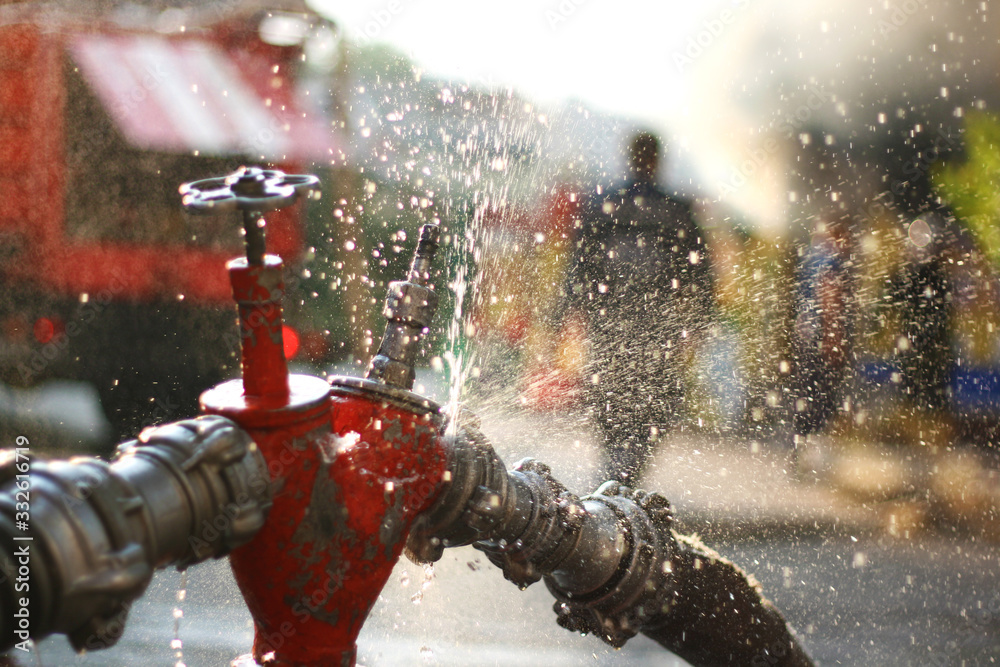 Foto de Water splashes from the fire hose and hydrant connections ...