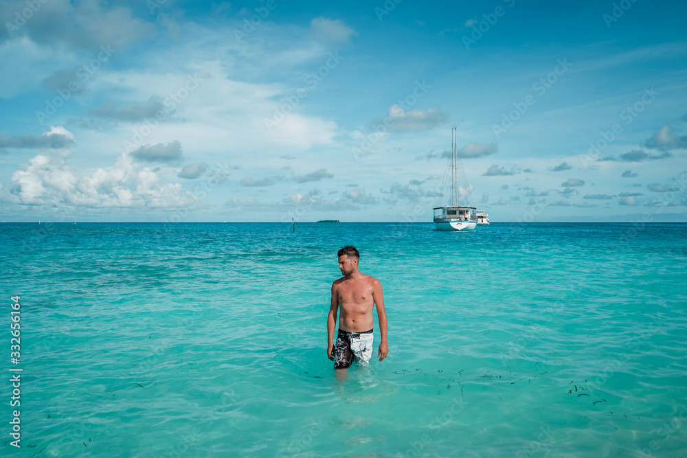 Maldives, young guy in swim short on the beach of the Maldives Island ...