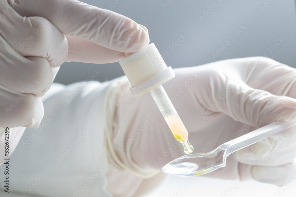 Pharmacologist make a cough syrup dose with pipette and spoon Stock ...