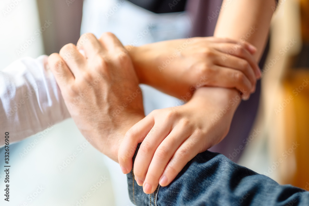 People putting their hands in a circle together for unity and teamwork ...