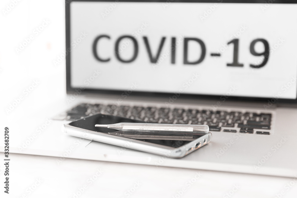Computer screen with the inscription Covid-19 and medical thermometer ...