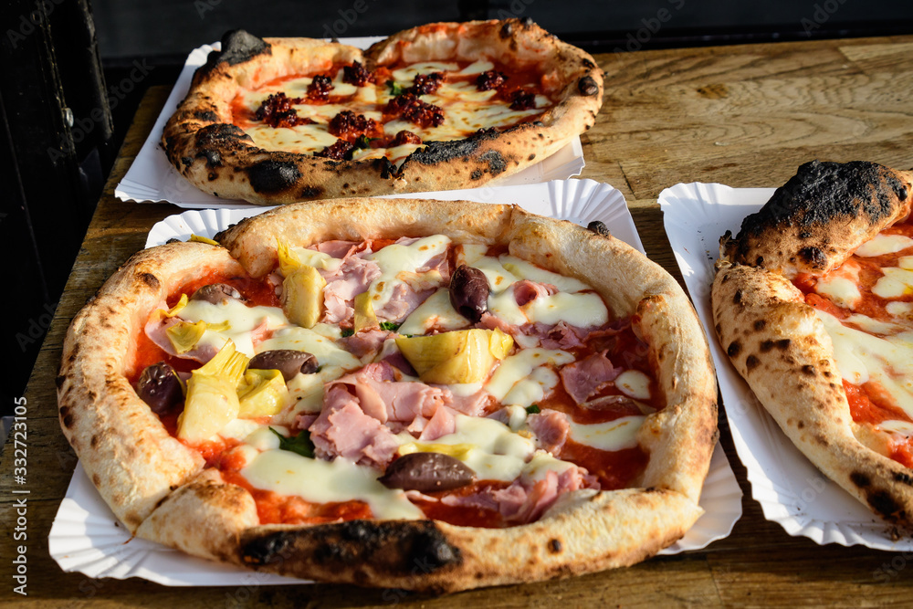 Traditional Italian pizza with prosciutto, artichoke and olives ...
