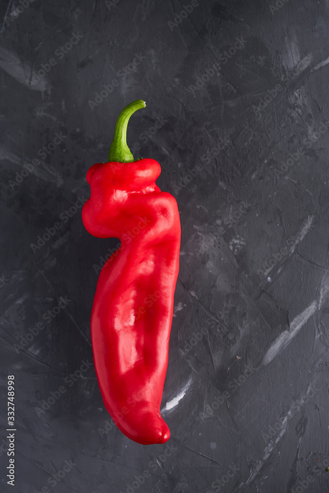 Trendy Ugly organic red pepper a black background. Funny, unnormal ...