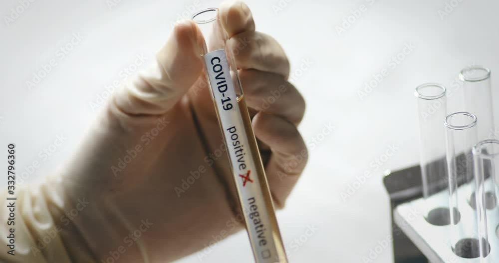 Conceptual video of a doctor holding and looking at a test tube while ...