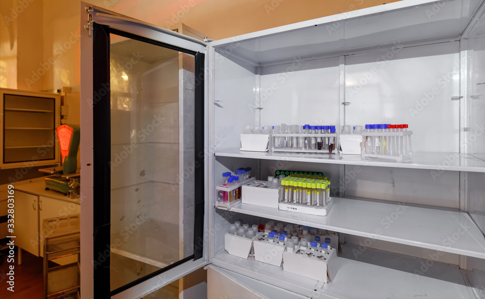 Disposable blood collection containers in an open metal cabinet of a ...