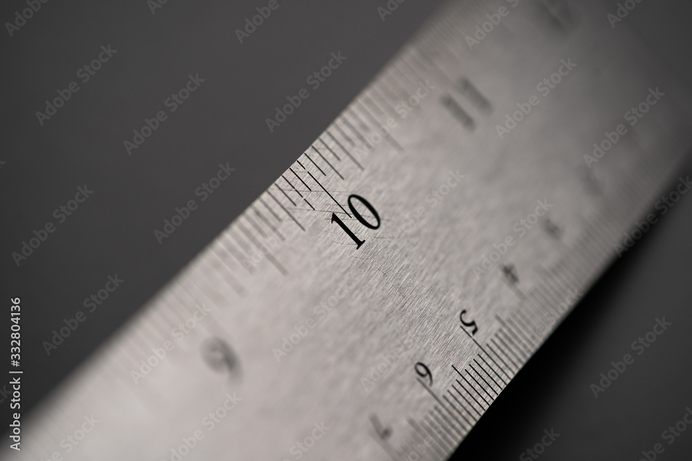 Metal ruler on a black leather isolated background with black numbers ...