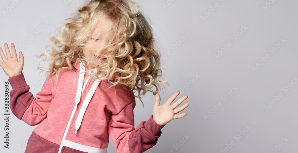 Kid girl in fashion pink gray hoodie is holding her hands up and ...