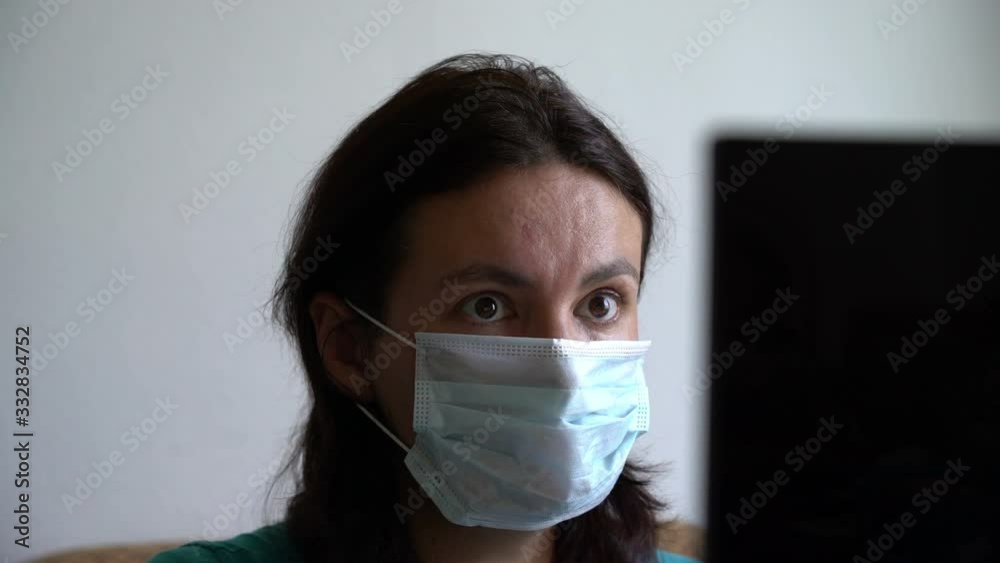woman put on mask, reading new about pandemia of virus on laptop ...