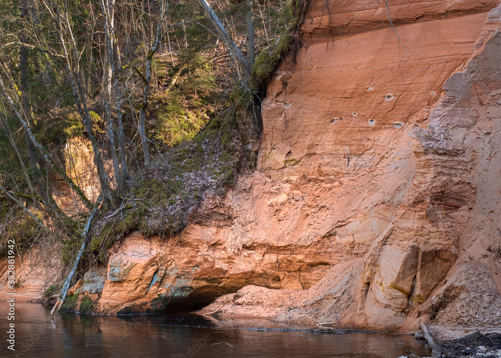 Foto de Sandstone rock wall at river with forest, rock reflection in ...
