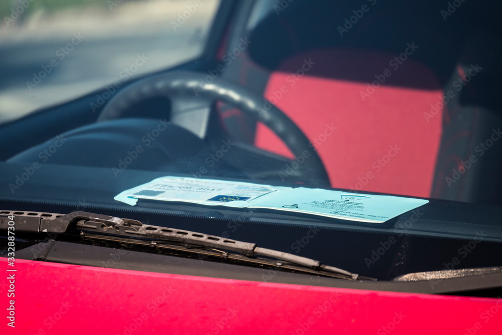 UK Blue badge disabled handicapped car parking sticker in windscreen of ...
