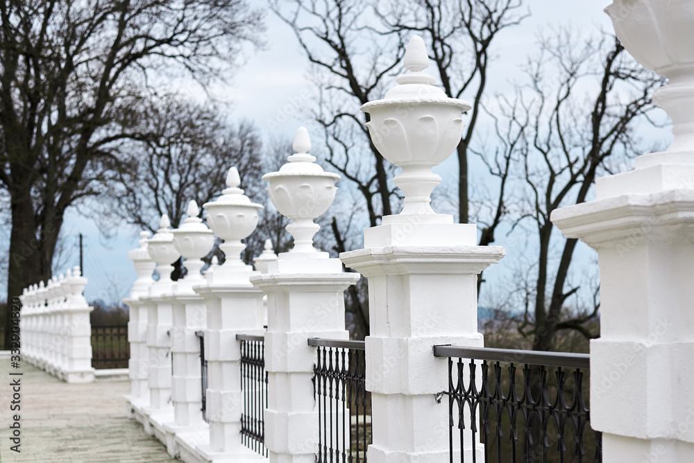 White concrete fence with curved pillars in old historical park of ...