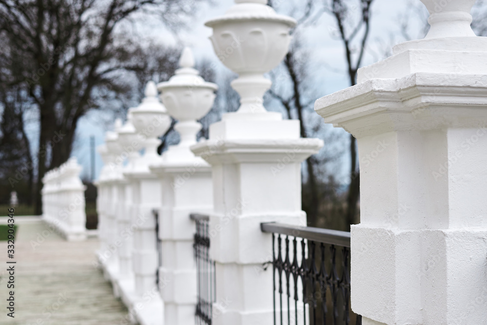 White concrete fence with curved pillars in old historical park of ...