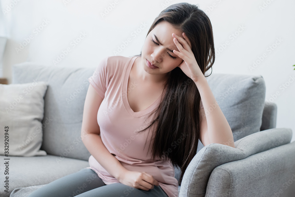 Sick asian woman with a hand on her head, severe headache with a face ...