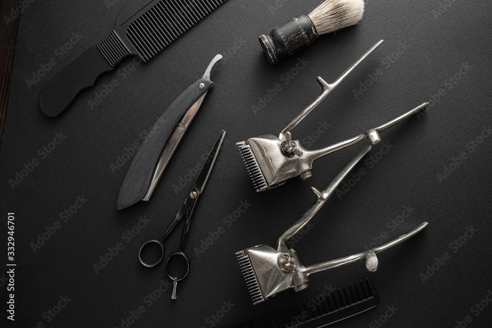 On a black surface are old barber tools. two vintage manual hair ...