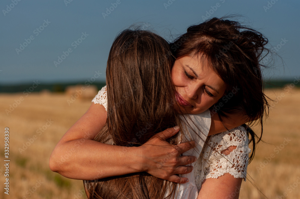 horizontal portrait of a middle-aged woman who hugs her daughter Stock ...