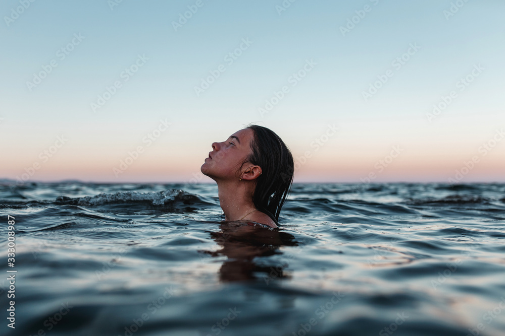 Woman floating in the sea Stock Photo | Adobe Stock